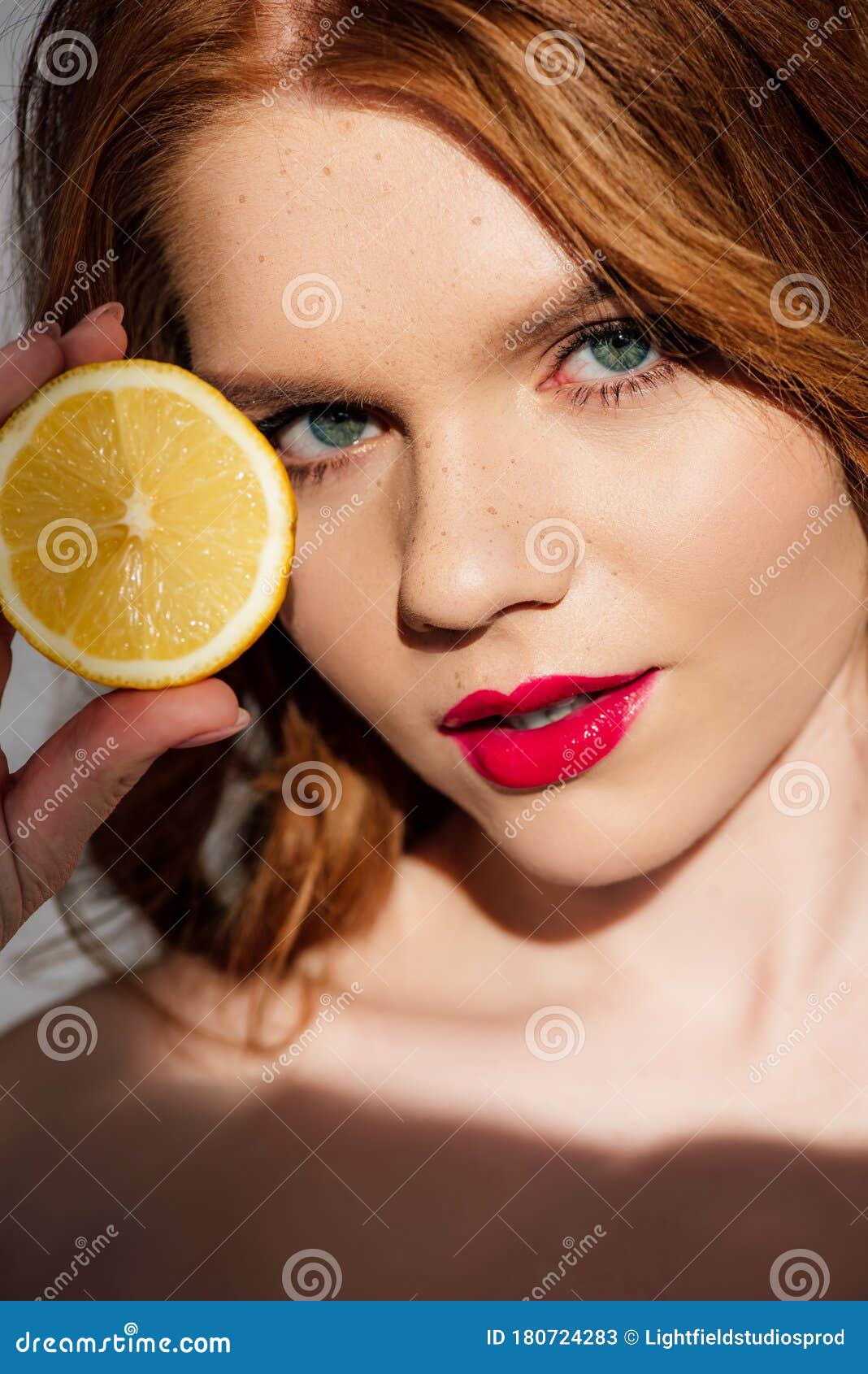 Beautiful Redhead Girl With Red Lips Posing With Cut Lemon And Looking
