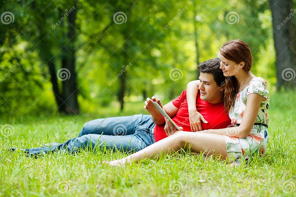 Beautiful Romantic Couple With Tablet Pc At Summer Green Park Stock