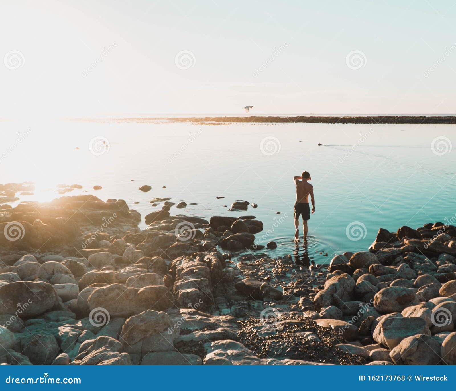Beautiful Scene of a Man Standing in the Water of the Ocean in Front of ...