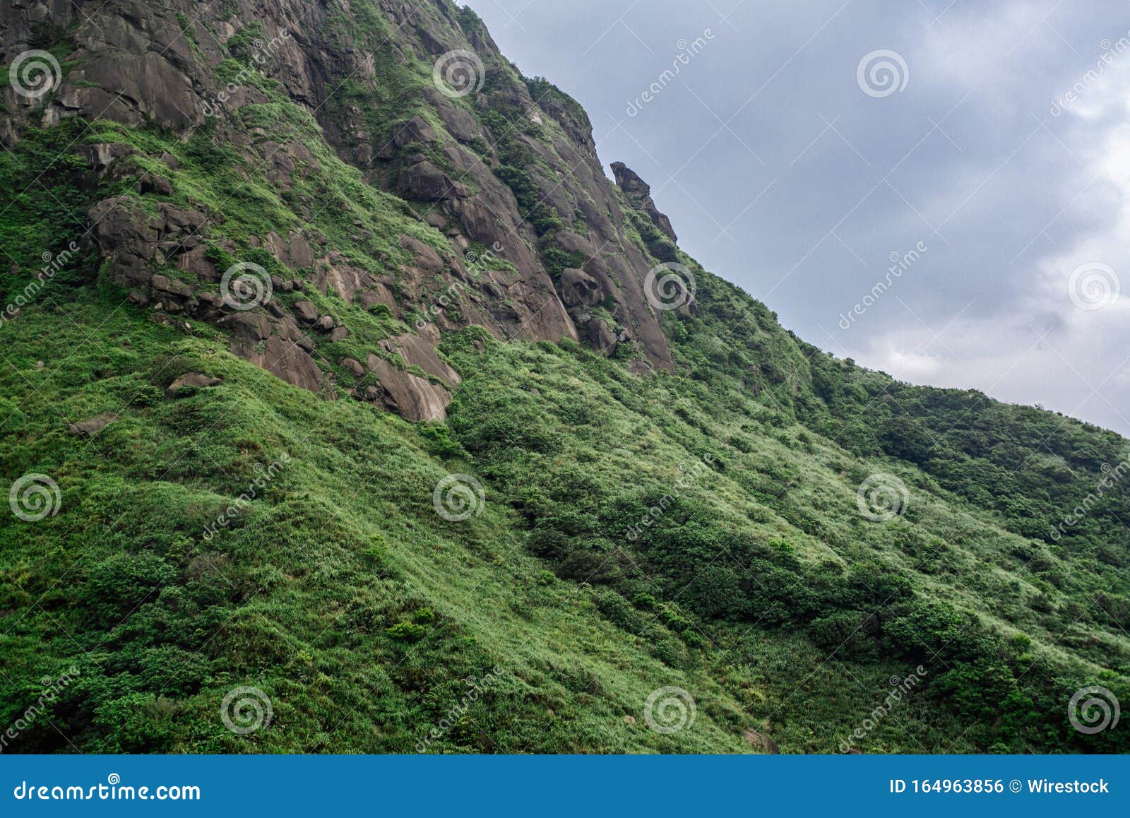 Beautiful Scenery of a Green Grassy Hill Under the Crazy Storm Clouds ...