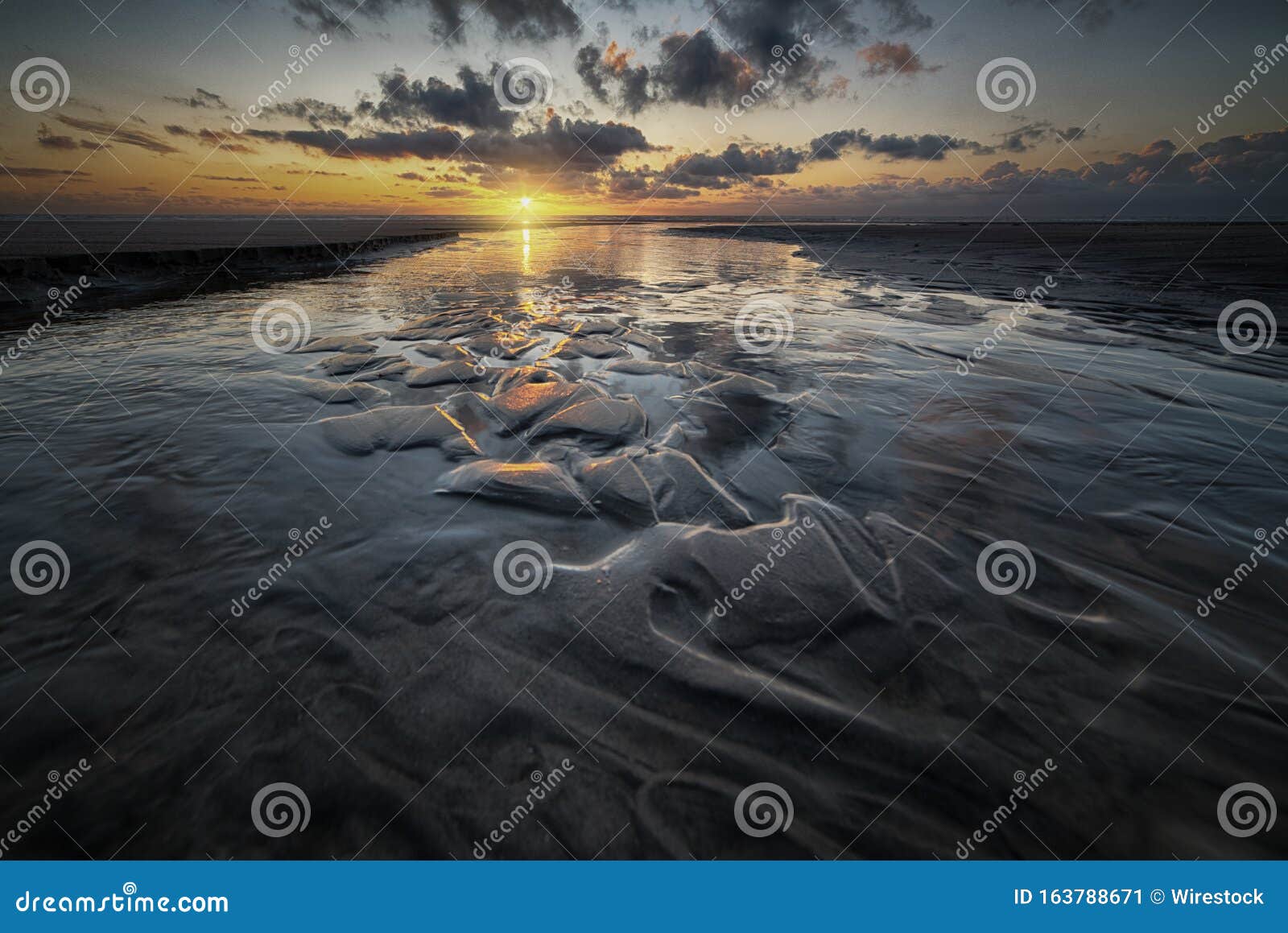 Beautiful Scenery of the Sunset Reflected in a Mudflat Under the Cloudy ...