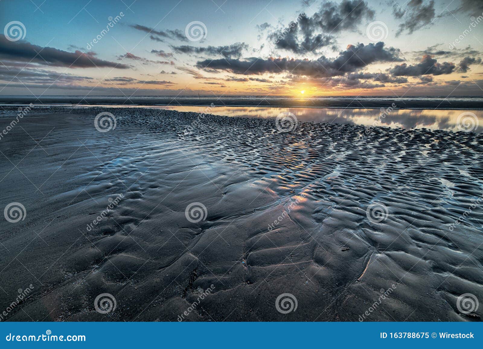 Beautiful Scenery of the Sunset Reflected in a Mudflat Under the Cloudy ...