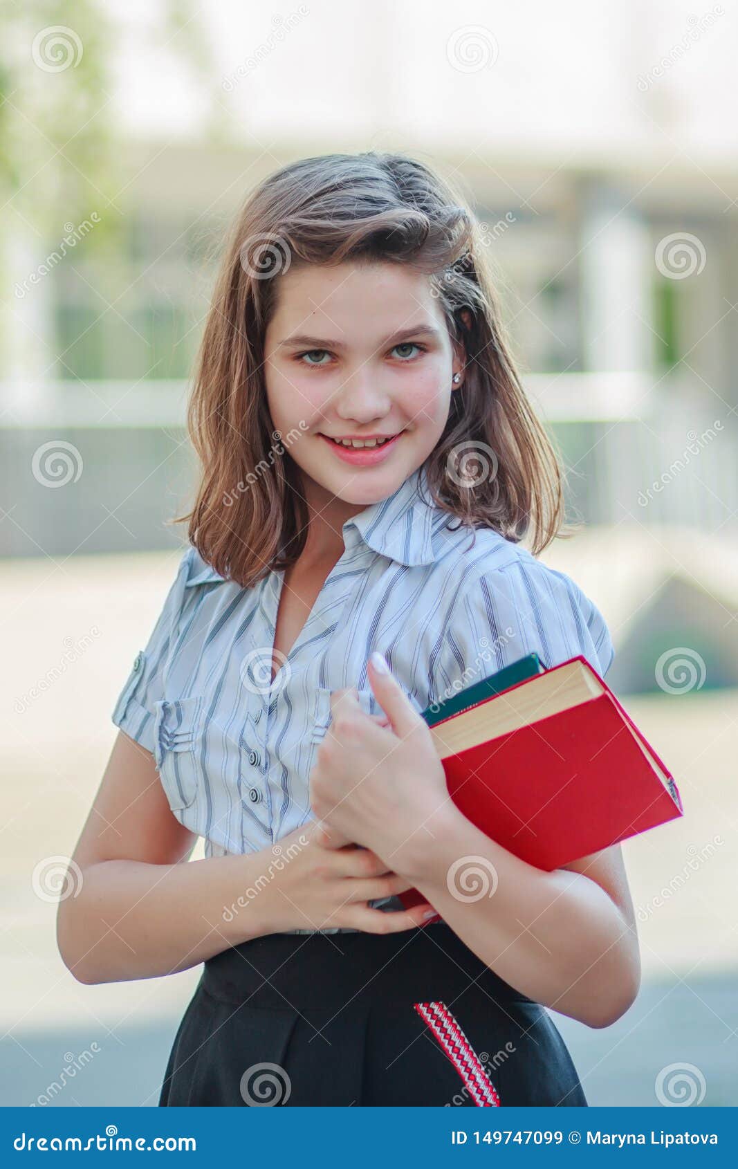 Beautiful Schoolgirl Teen Holds Textbooks. Pupil in Front of School in ... Beautiful Schoolgirl Teen Holds Textbooks. Pupil in Front of School in ...