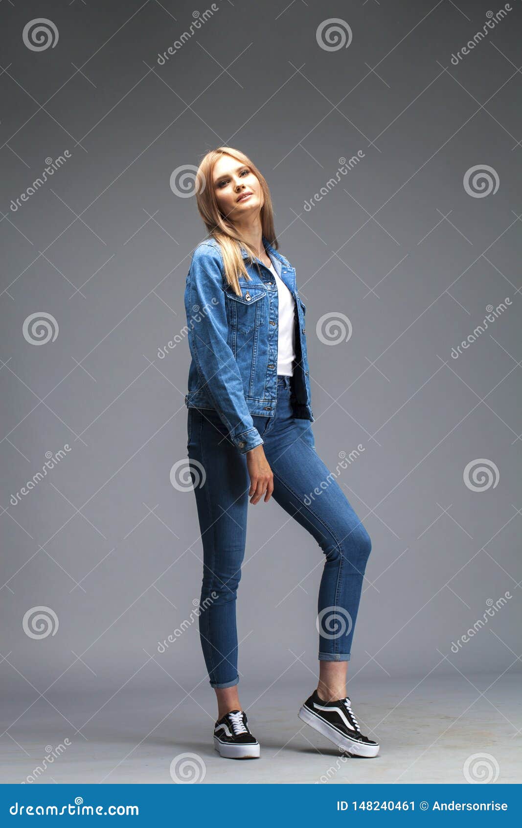 Beautiful Blonde Woman Dressed In A Denim Jacket And Blue Jeans Stock