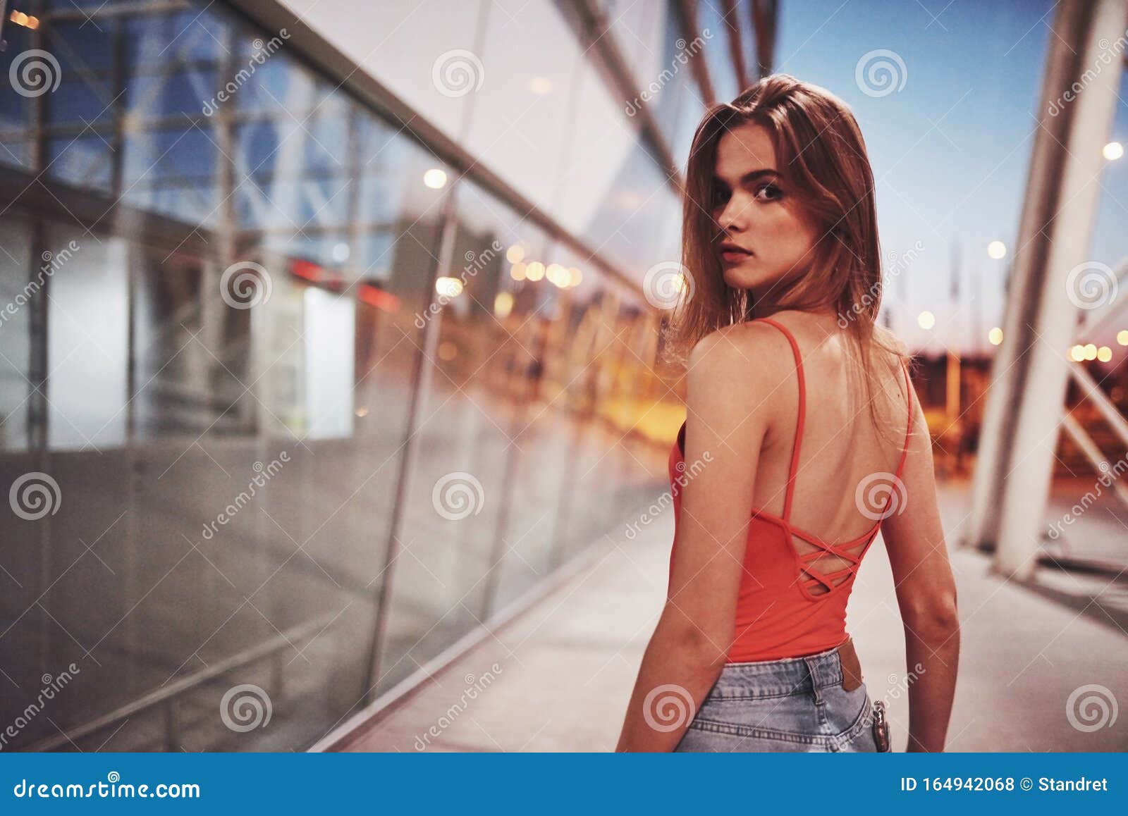 Beautiful Tourist Girl Walking In Busy City Street Near The Airport