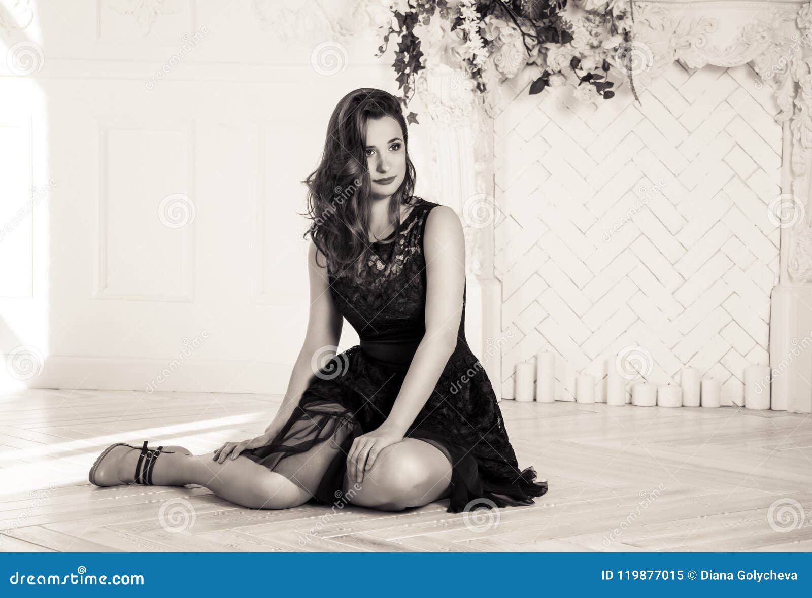 Beautiful Young Woman In Black Dress Is Sitting On The Floor Young