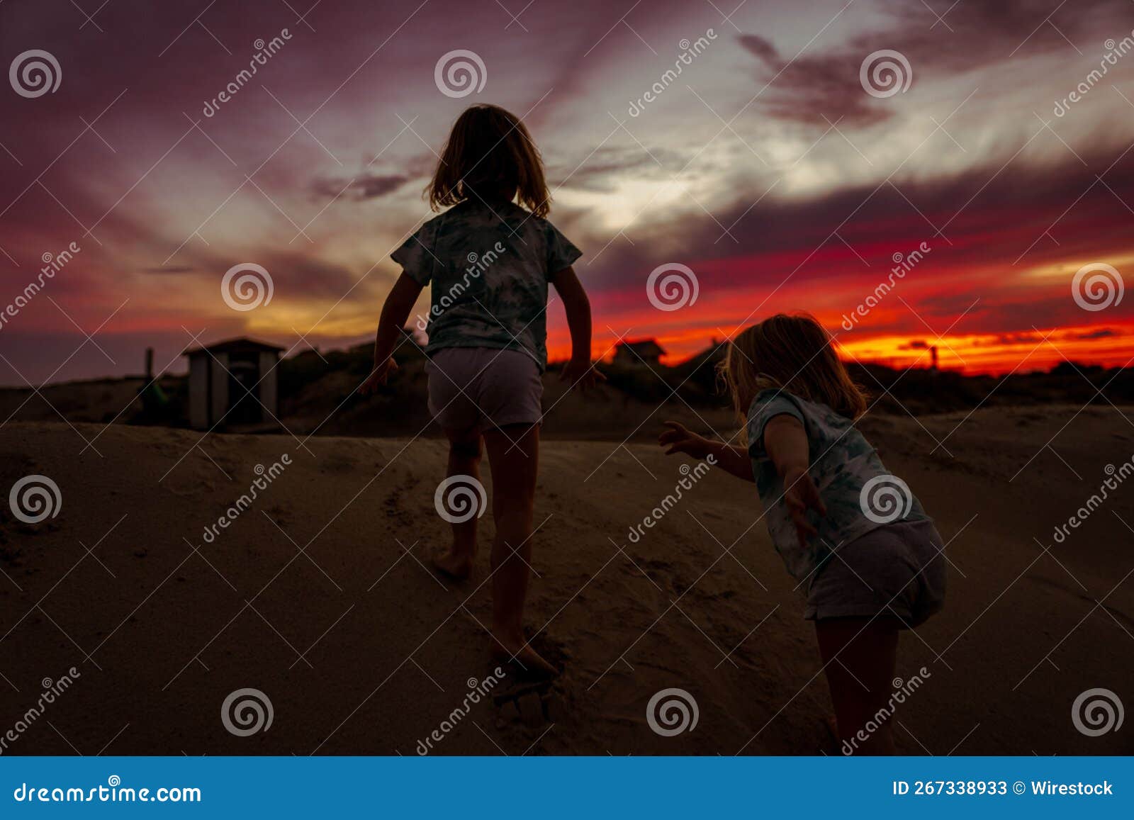 Beautiful Shot of Two Small Girls Rolling Down a Sand Slide during ...