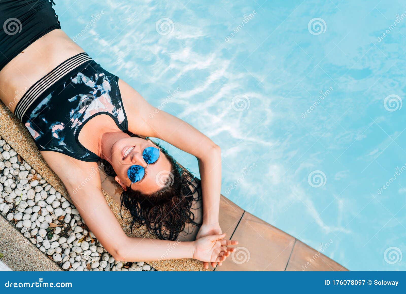 Beautiful Sincerely Smiling Woman In Blue Sunglasses Lying On The