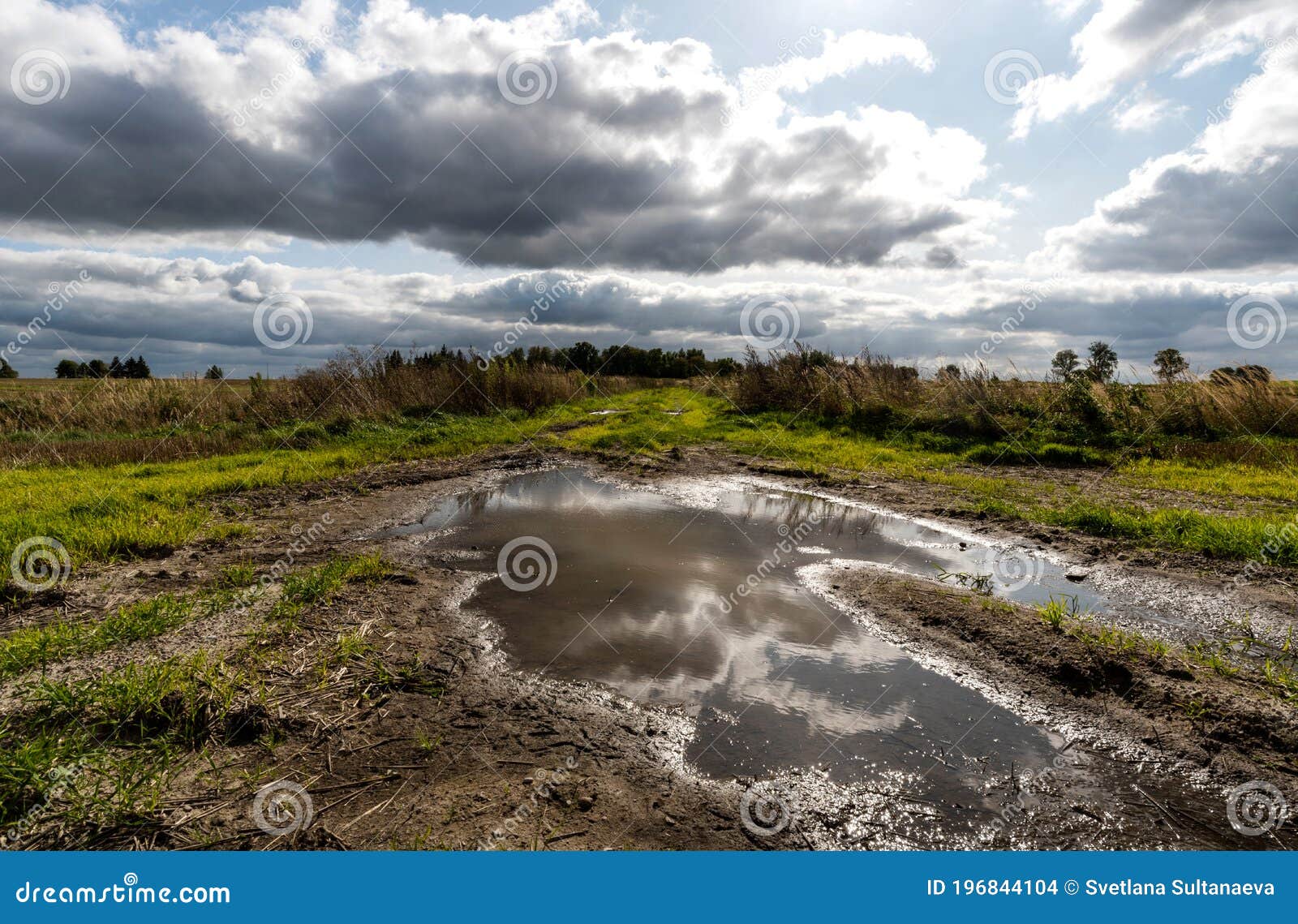 Beautiful Sky with Clouds is Reflected in a Puddle on a Country Road ...