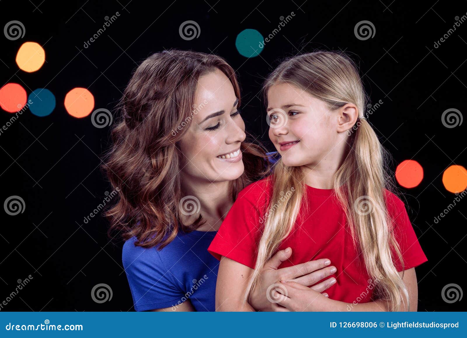 Portrait Of Beautiful Smiling Mother And Daughter Looking At Each Other