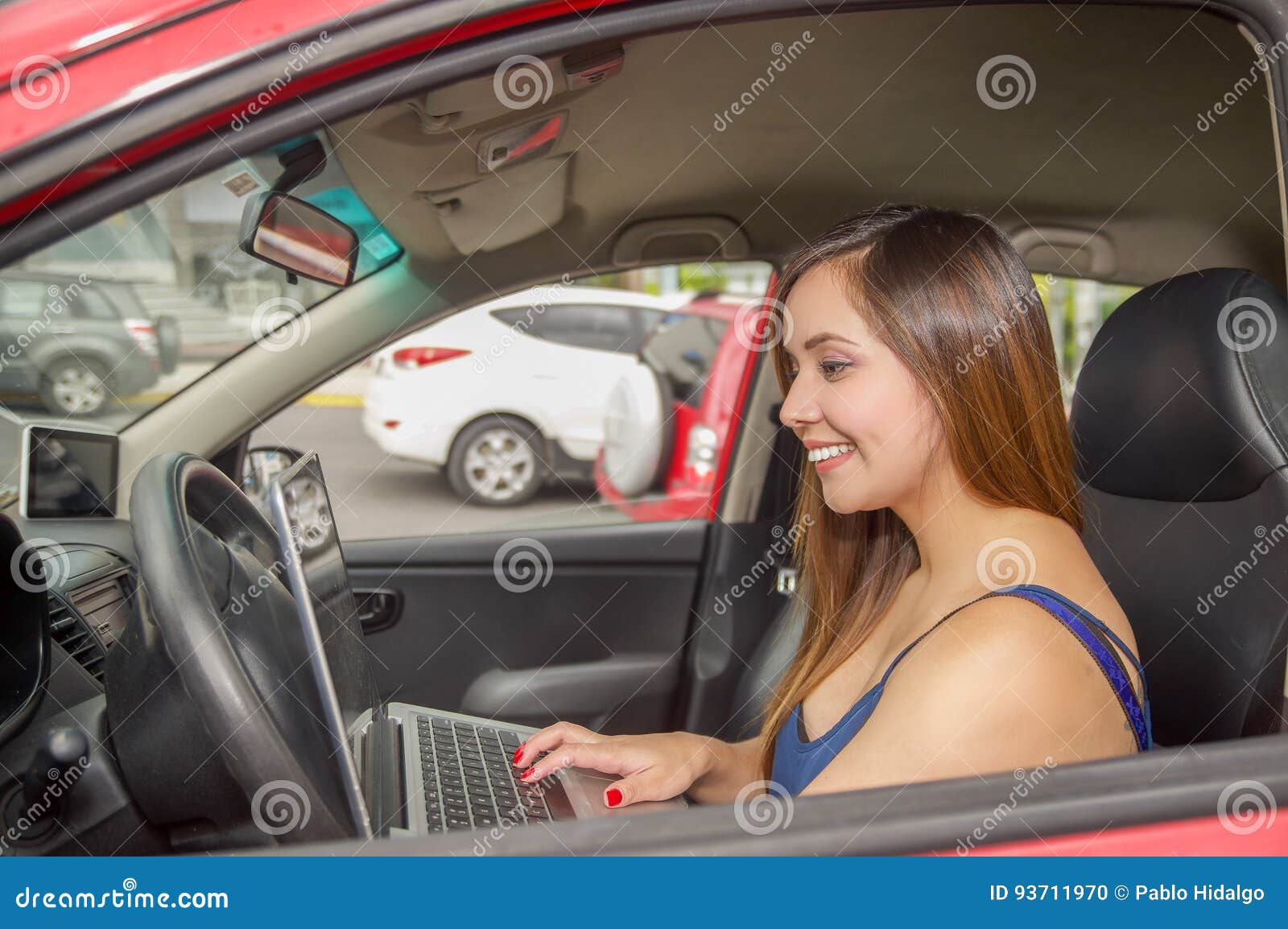 Beautiful Smiling Young Lady Working in Her Computer, while the Car ...