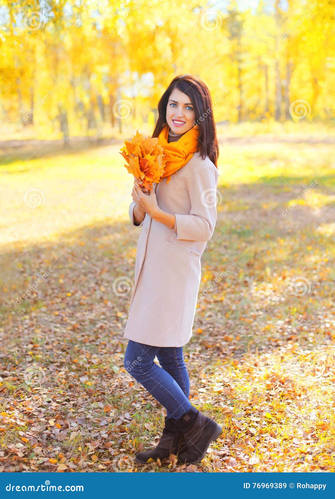 Beautiful Smiling Young Woman With Yellow Maple Leafs In Sunny Autumn