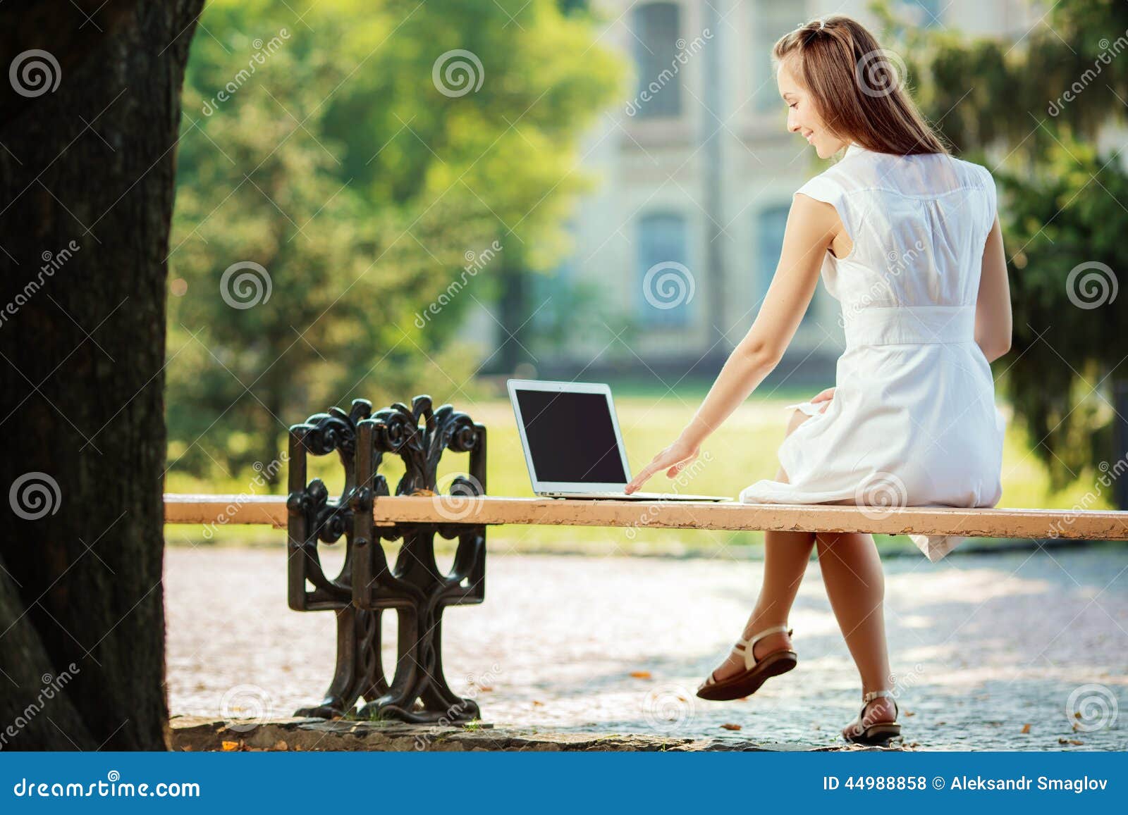 Beautiful Student Woman is Using a Laptop and Sitting on a Bench Stock ...