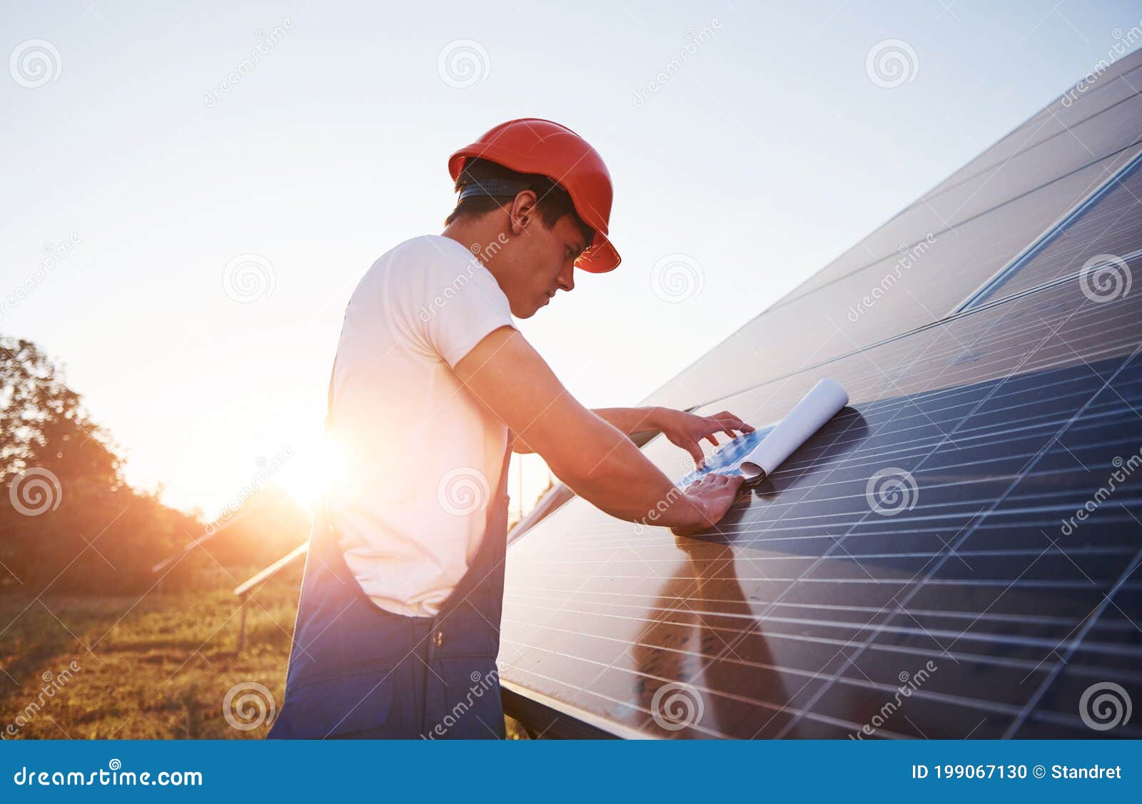 Beautiful Sunlight. Male Worker in Blue Uniform Outdoors with Solar ...