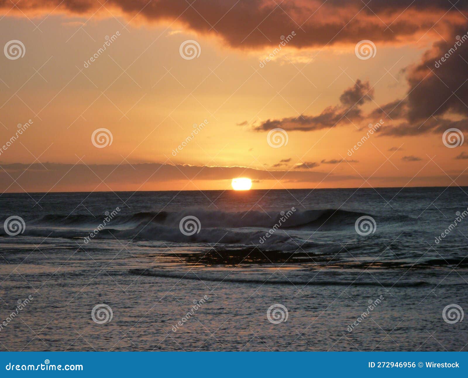 Beautiful Sunset Captured Over a Beach, with Rolling Waves Lapping Up ...