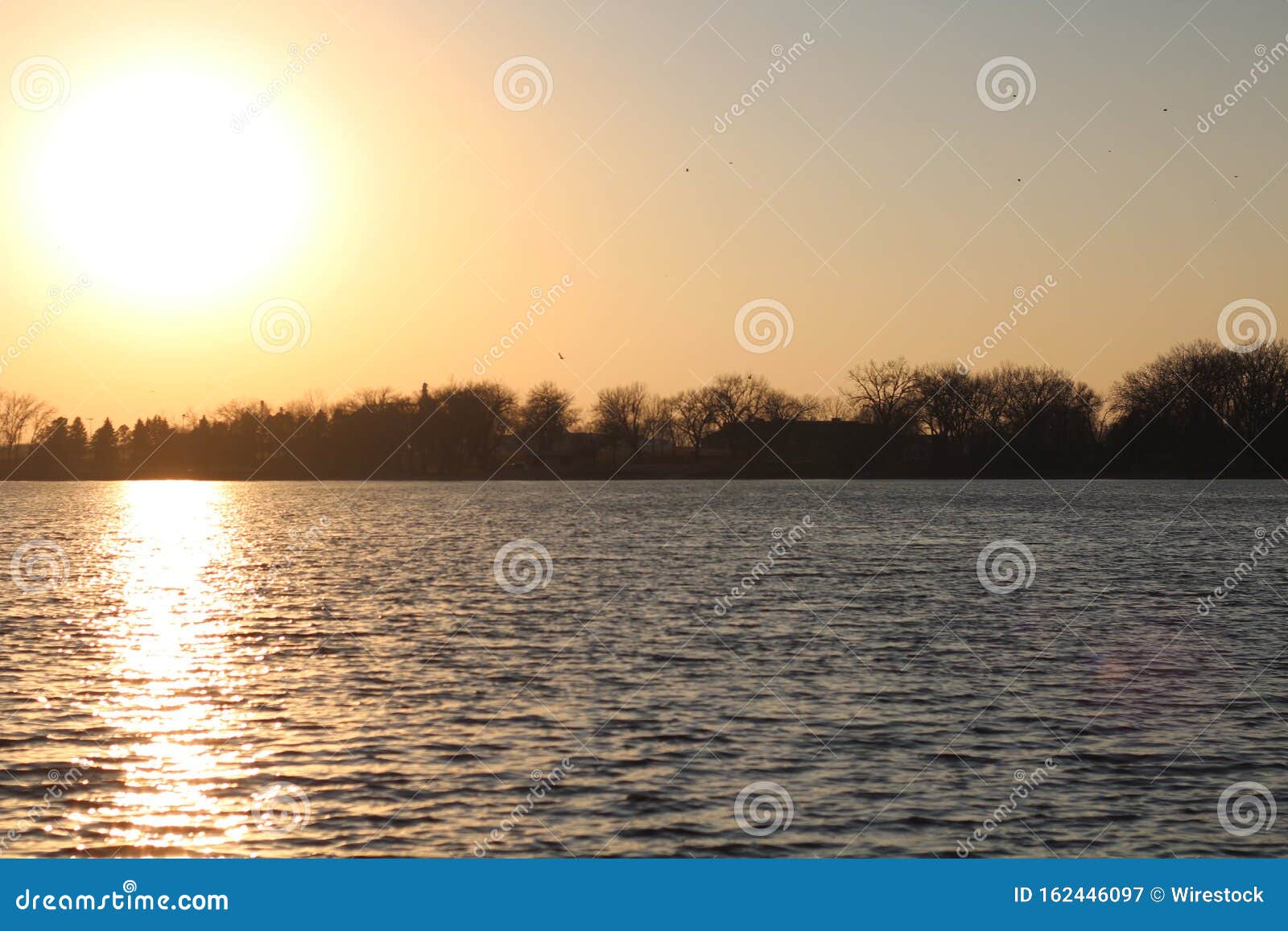 Beautiful Sunset Over a Lake with a Tree Line Stock Image - Image of ...