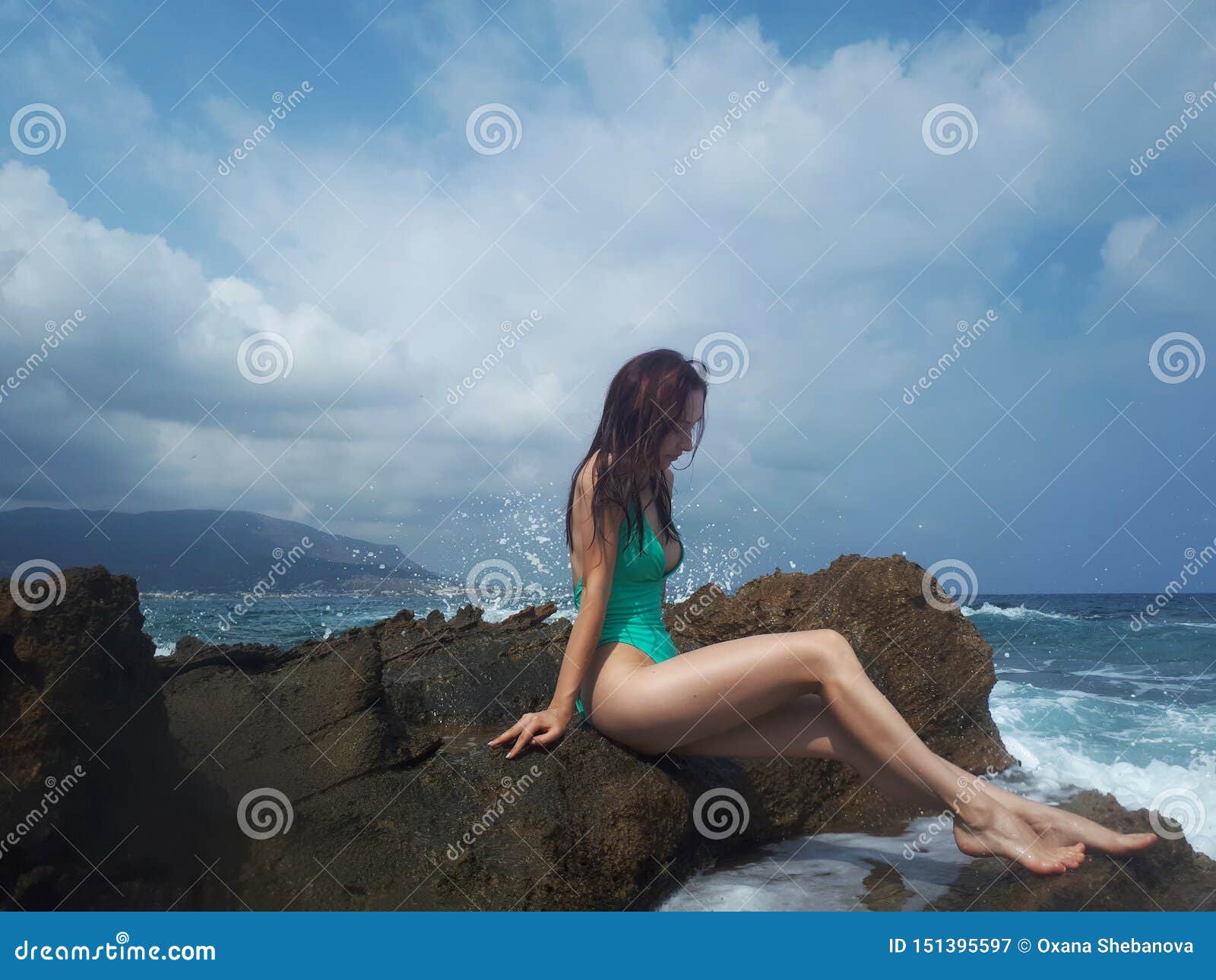 Beautiful Tanned Caucasian Woman Resting On The Rock Sea Beach Crete