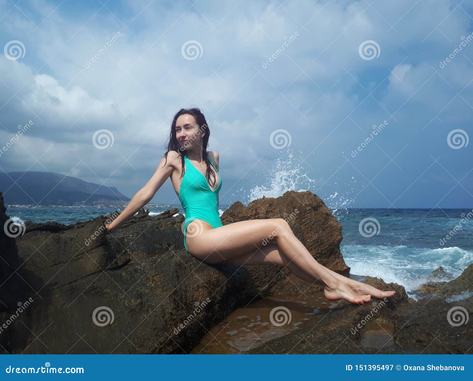 Beautiful Tanned Caucasian Woman Resting On The Rock Sea Beach Crete