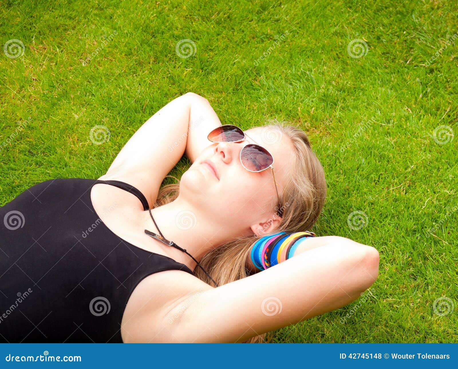 Beautiful Teenage Girl With Sunglasses Lying On Her Back In The Stock