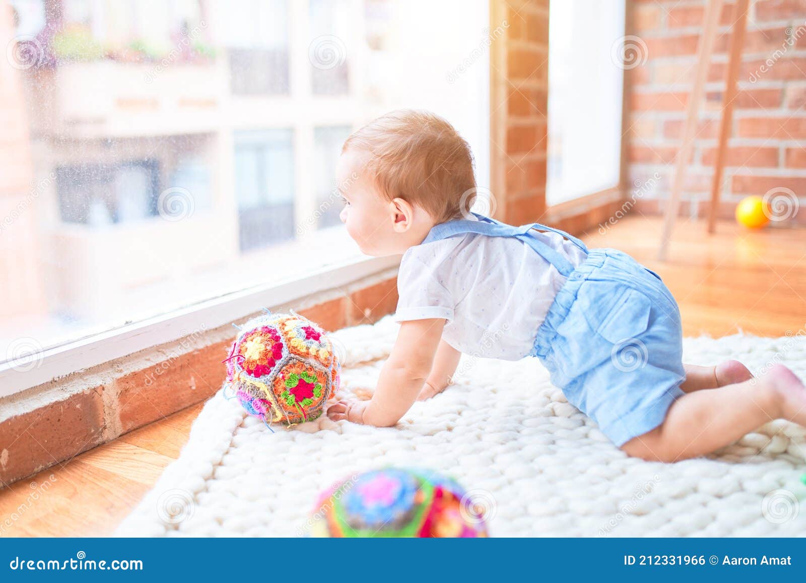 Beautiful Toddler Crawling on the Blanket Looking through the Window at ...