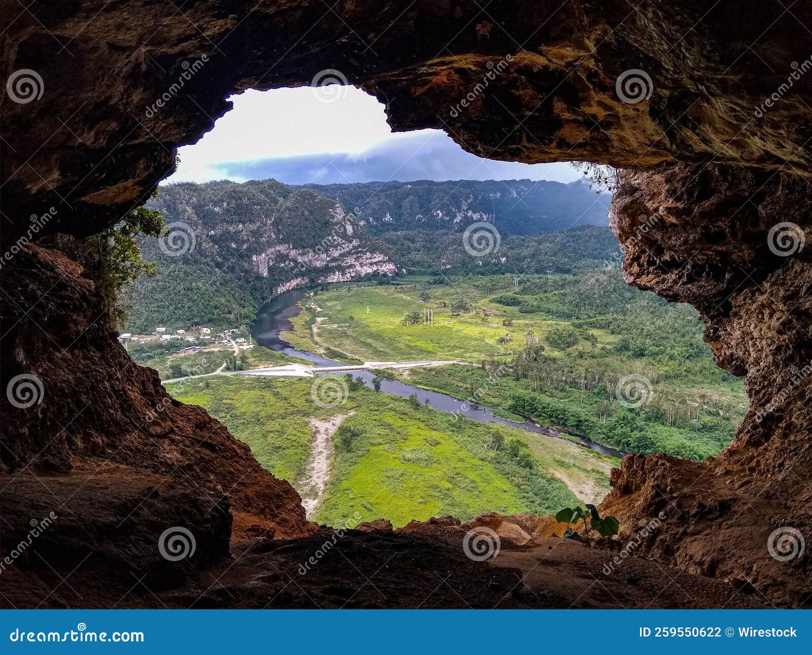 Beautiful View of a Landscape with a River and Fields from a Cave Stock ...