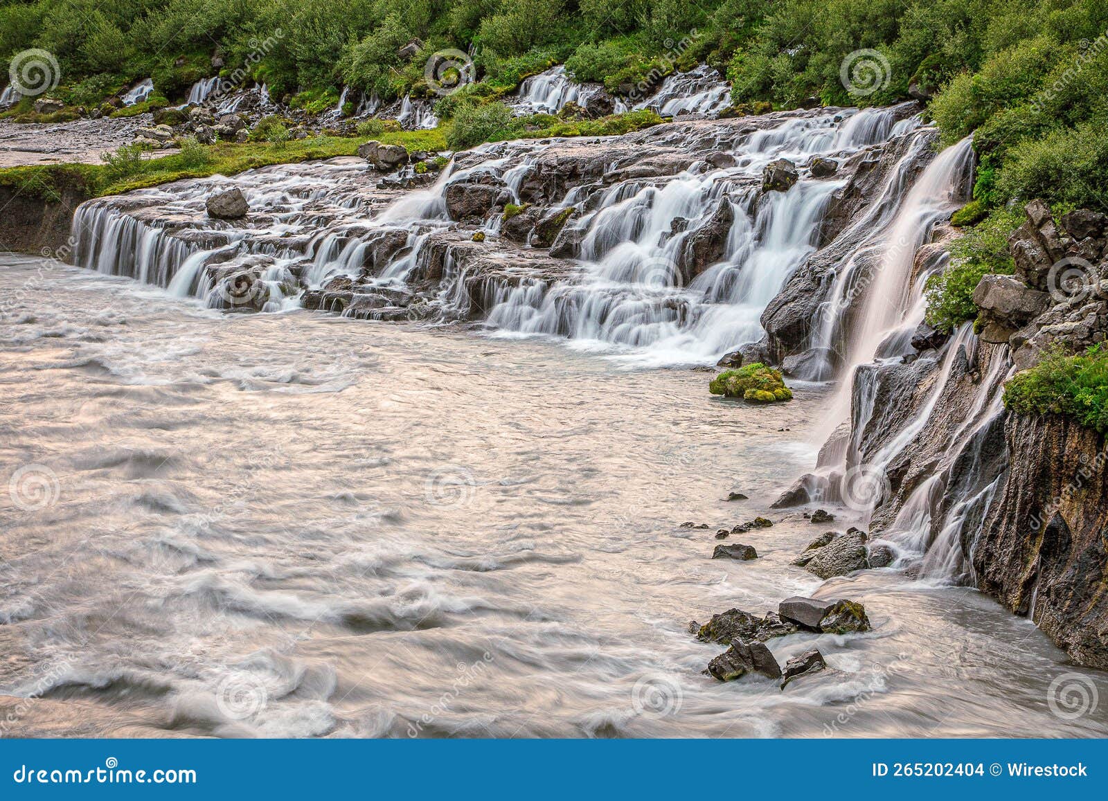 Beautiful Waterfall Flowing Over the Rocks in Iceland with Lush Trees ...