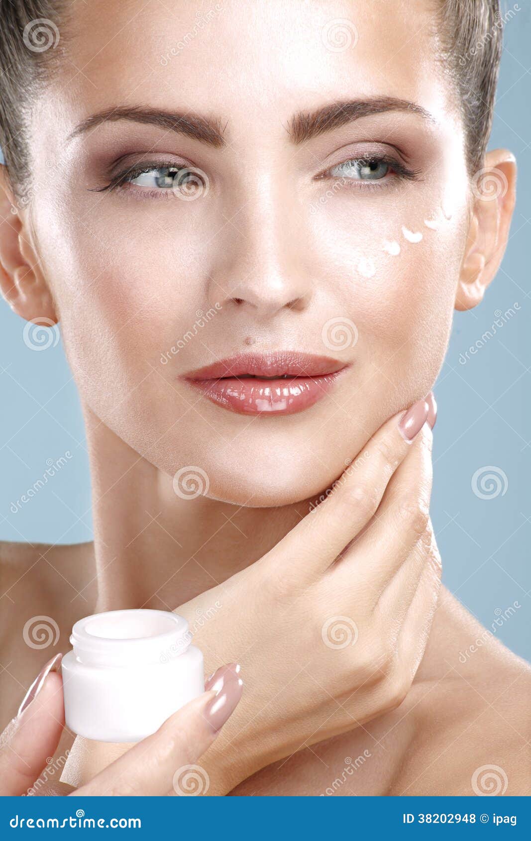 Beautiful Woman Applying Cream Treatment On Her Perfect Face Stock