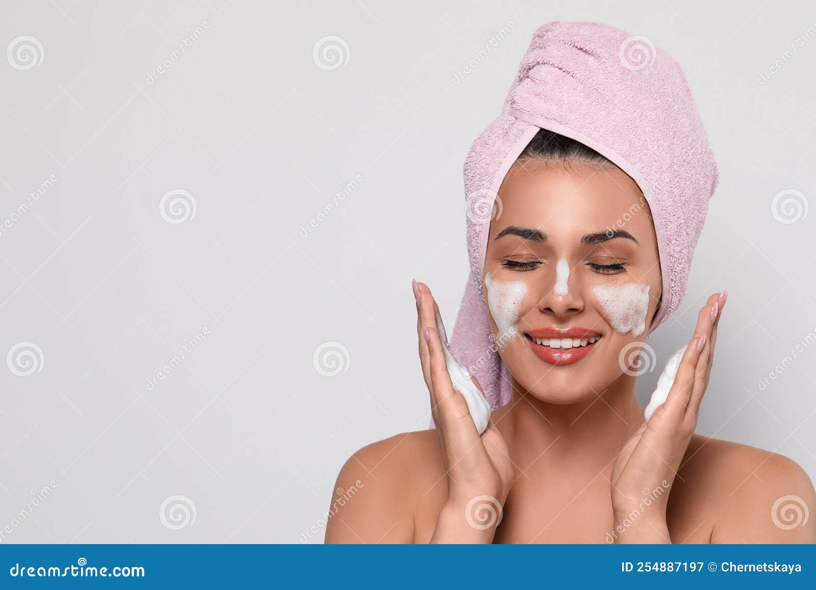 Beautiful Woman Applying Facial Cleansing Foam On Background Space For