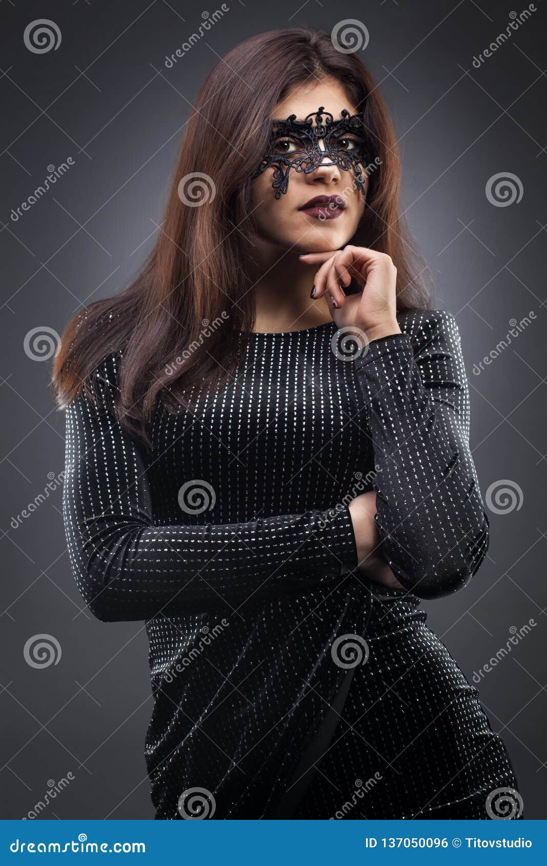 Beautiful Woman With Black Lace Mask Over Her Eyes On The Dark Gray