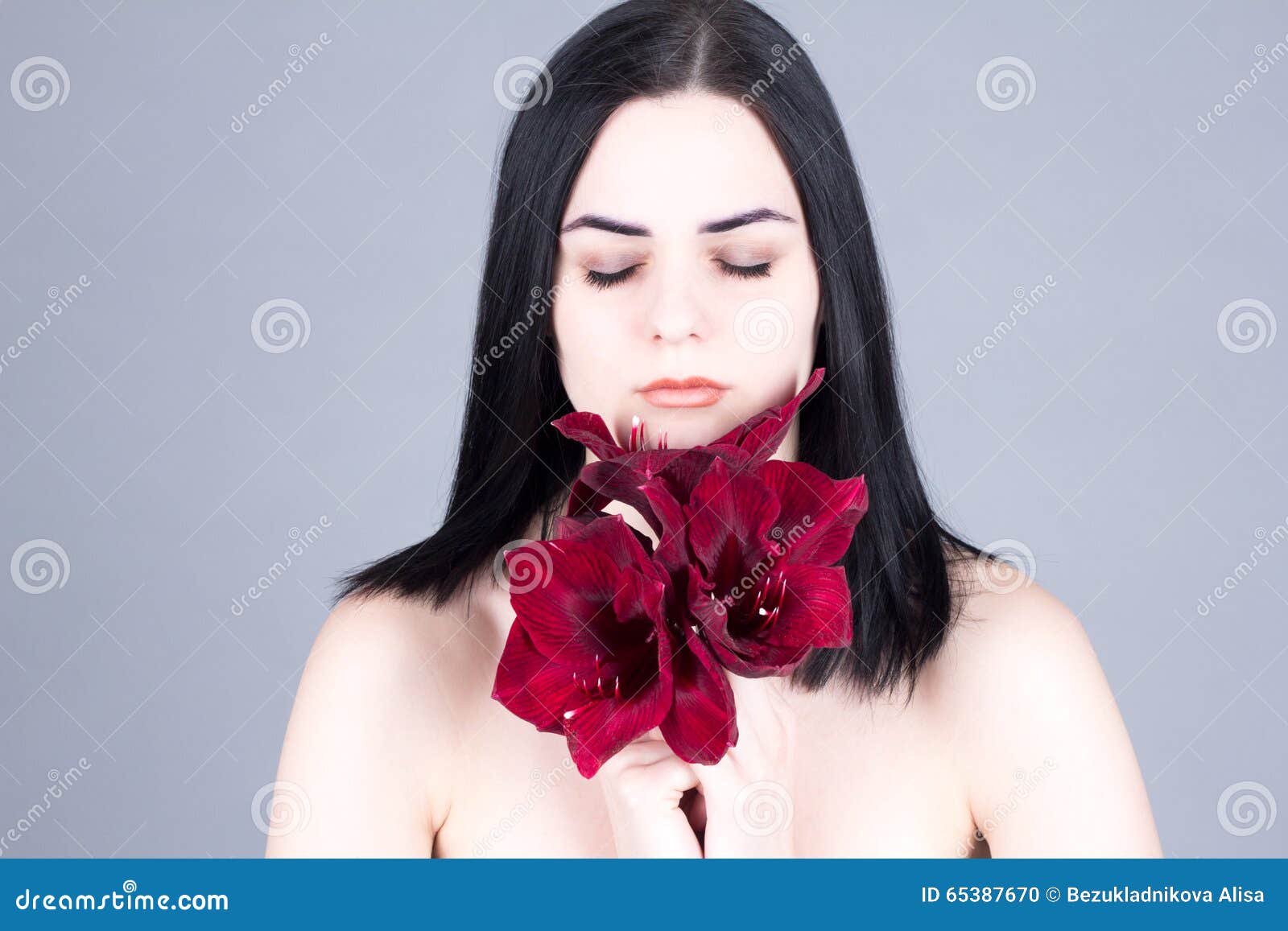 Beautiful Woman With Clean Face And With Red Flowers In Hands Stock