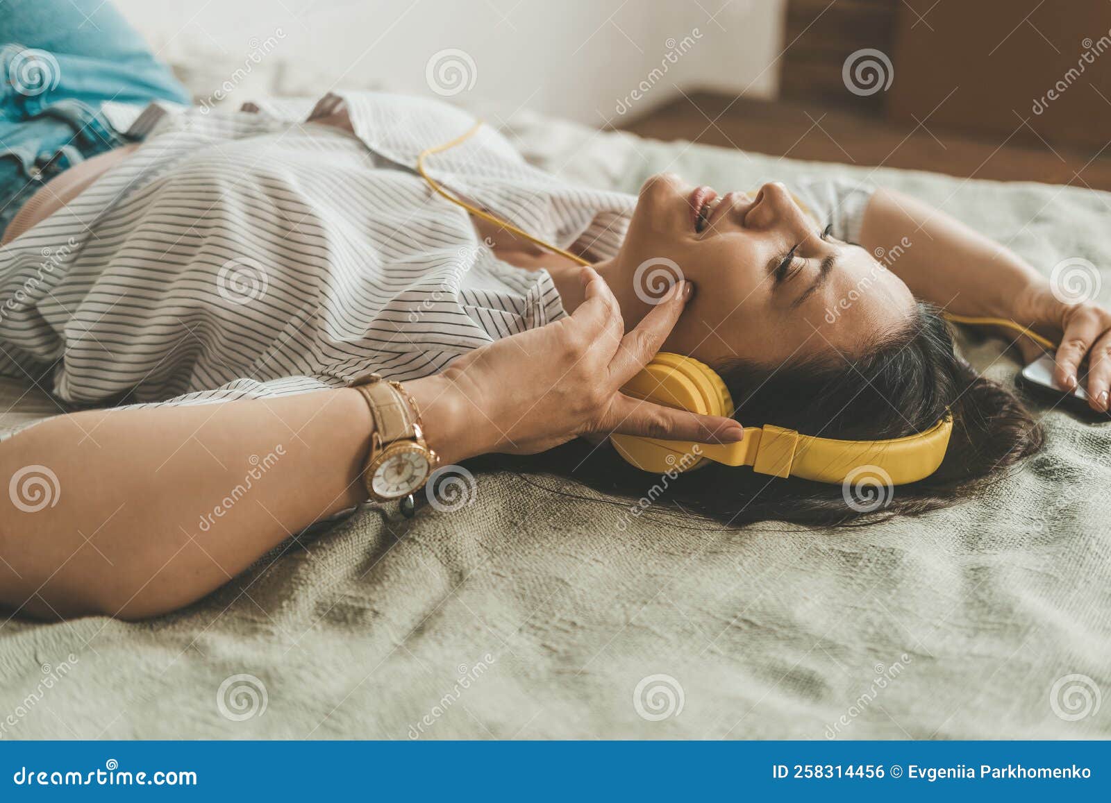 A Beautiful Woman with Dark Hair is Lying on the Bed at Home in ... A Beautiful Woman with Dark Hair is Lying on the Bed at Home in ...