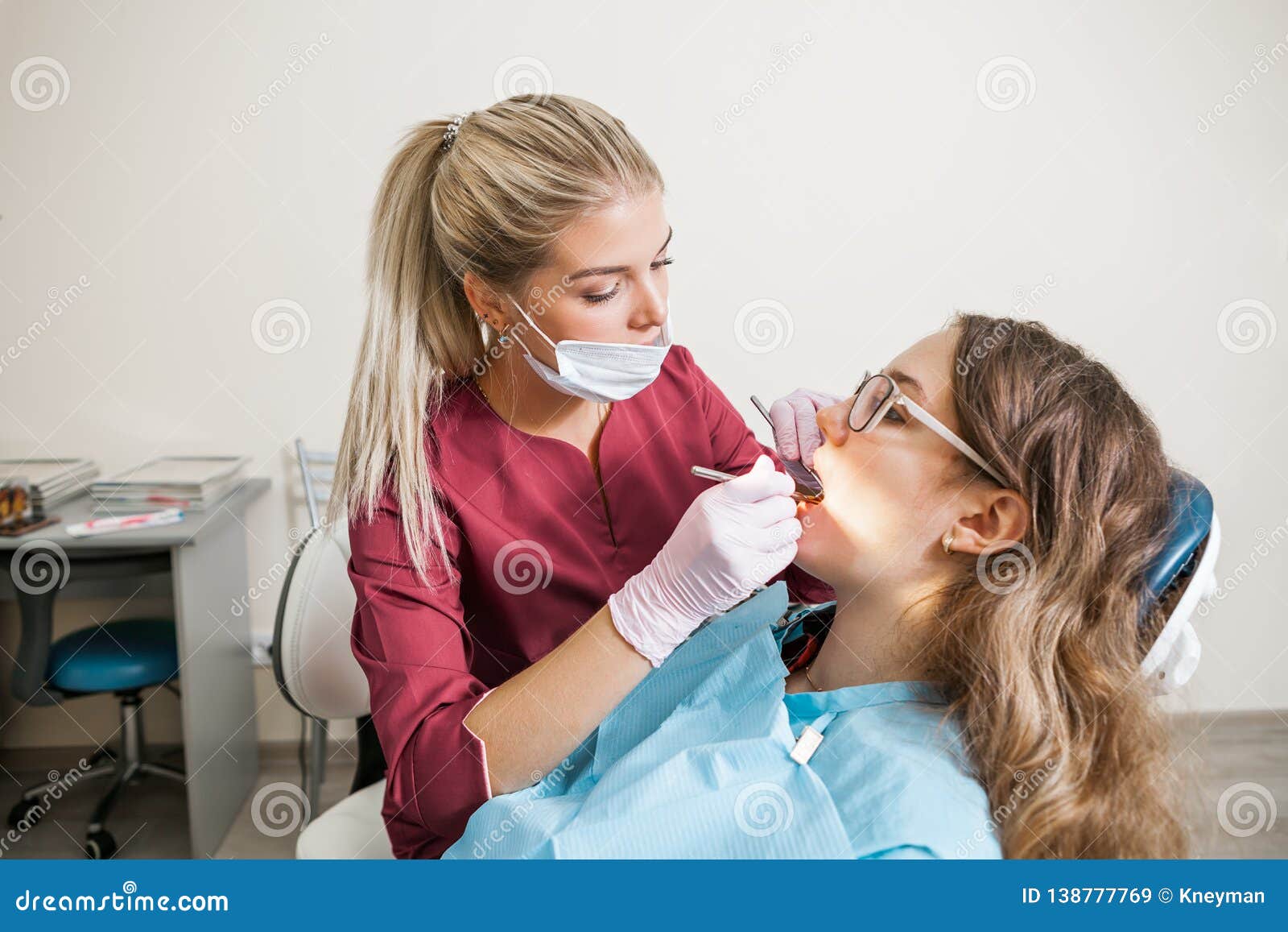 Beautiful Woman Dentist In The Mask Examines A Patient In The Dental