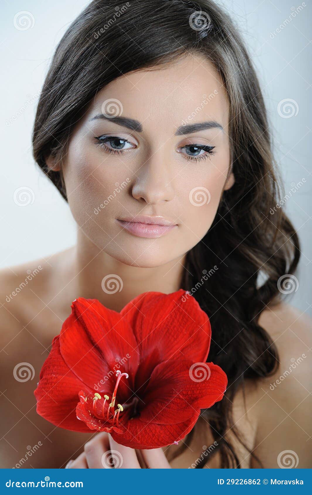 Beautiful Woman With Fresh Health Skin Of Face And Red Flower In Hand