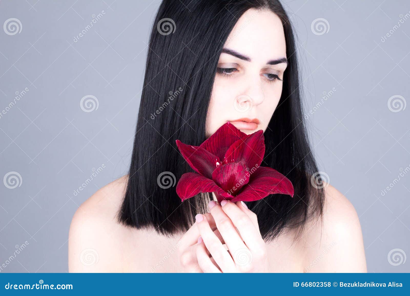 Beautiful Woman Looking Down with Flower in Hands Stock Photo - Image ...