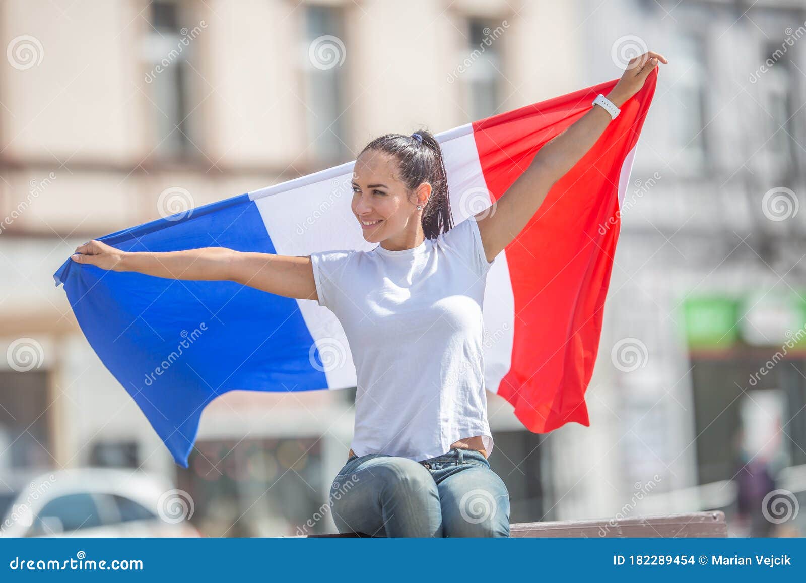 Beautiful Woman Looks To the Side Smiling, Holding a Flag of France ... Beautiful Woman Looks To the Side Smiling, Holding a Flag of France ...