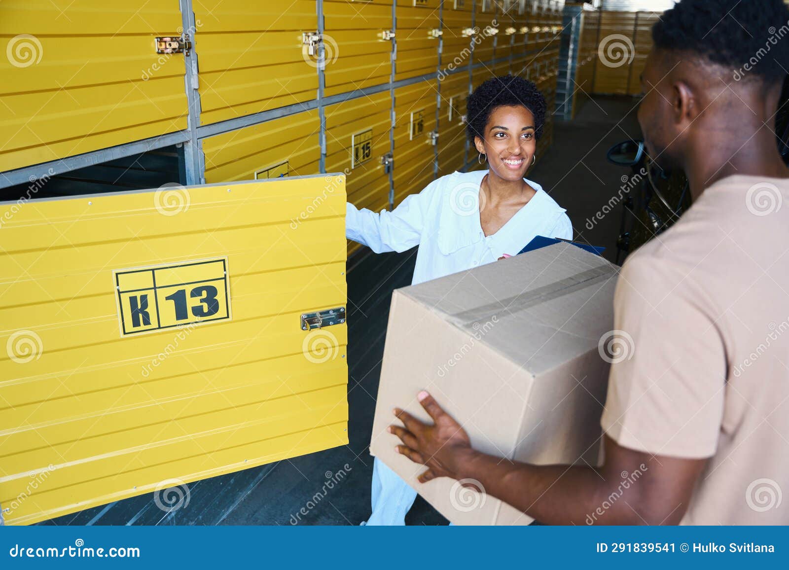 Beautiful Woman Manager Opens Cell for Storing Things for Client Stock ...