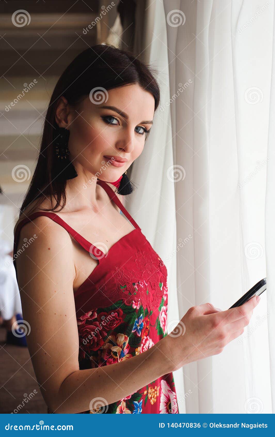 Beautiful Woman with Mobile Phone by the Window. Stock Photo - Image of ...