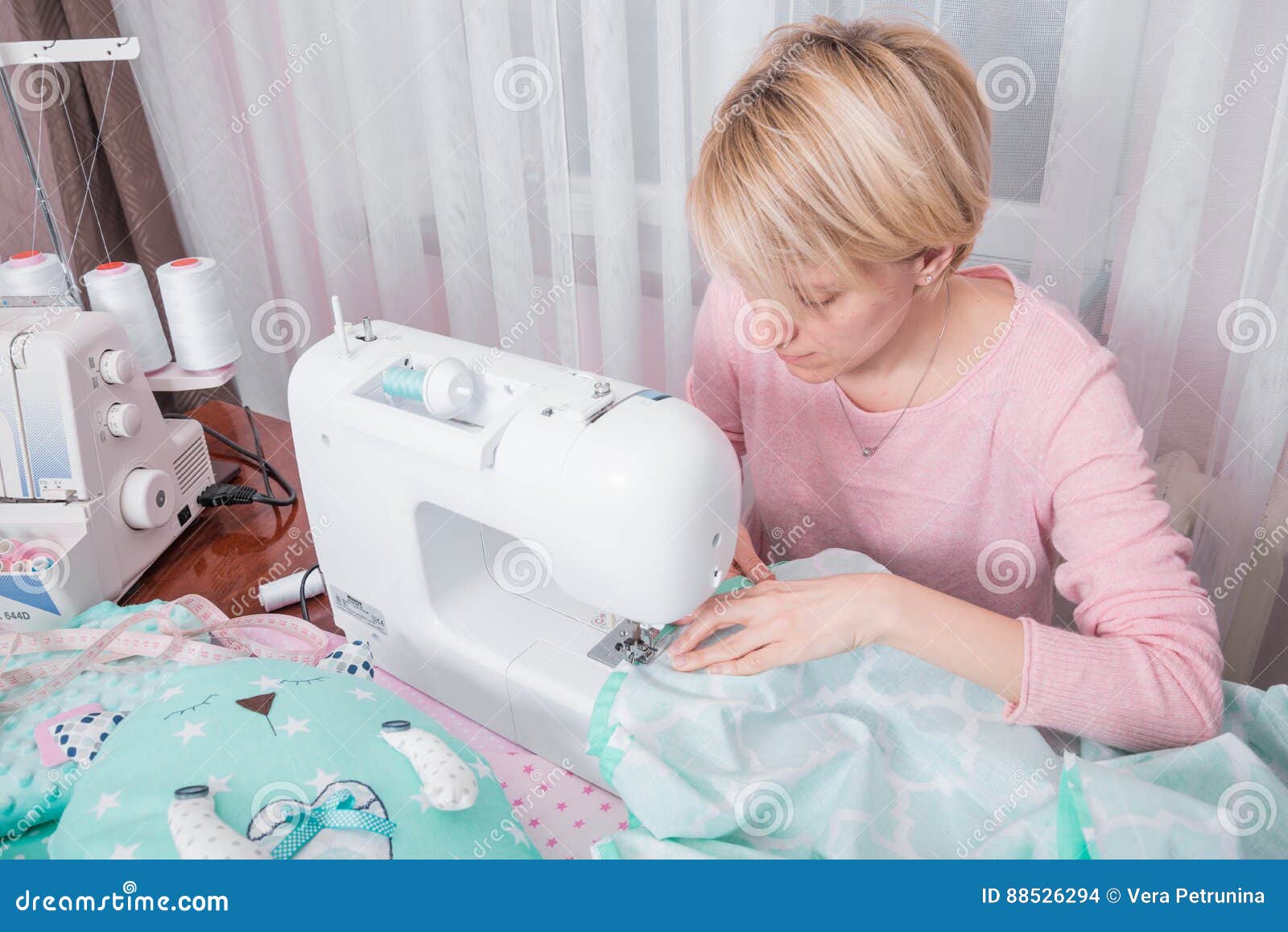 Beautiful Woman Seamstress Sew On The Sewing Machine Clothes Stock
