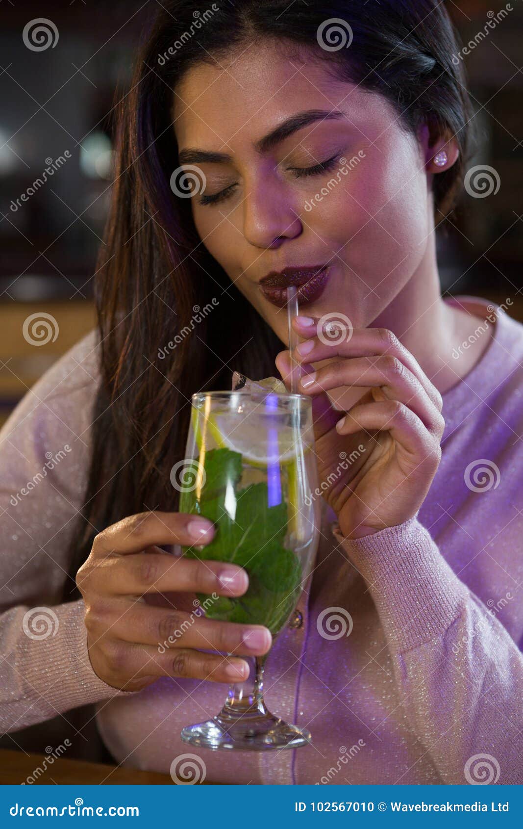 Woman sipping on a drink stock photo. Image of smiling - 102567010