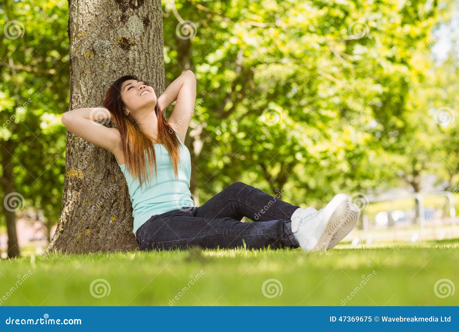 Beautiful Woman Sitting Against Tree in Park Stock Image - Image of ...
