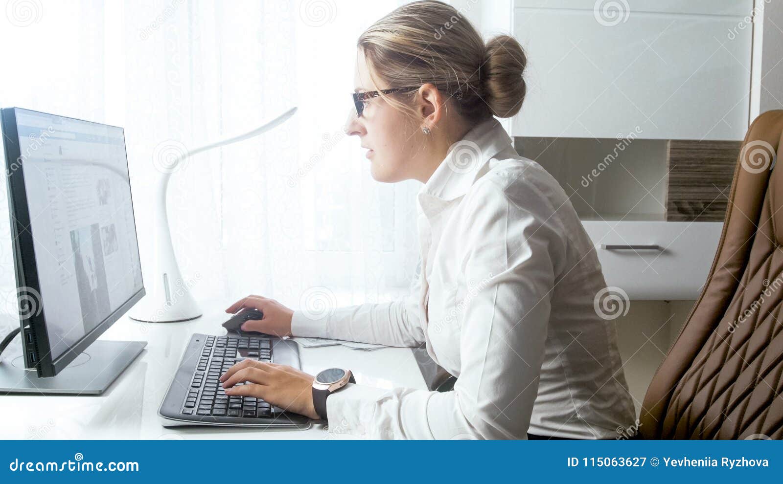 Beautiful Young Woman Sitting Behind Desk and Using Computer Stock ...