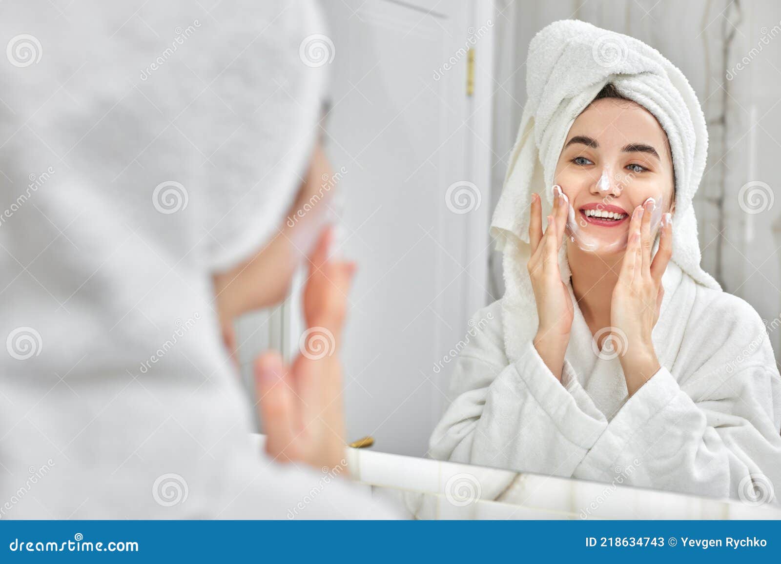 Woman In White Bathrobes Applying Apply Facial Cream Stock Image