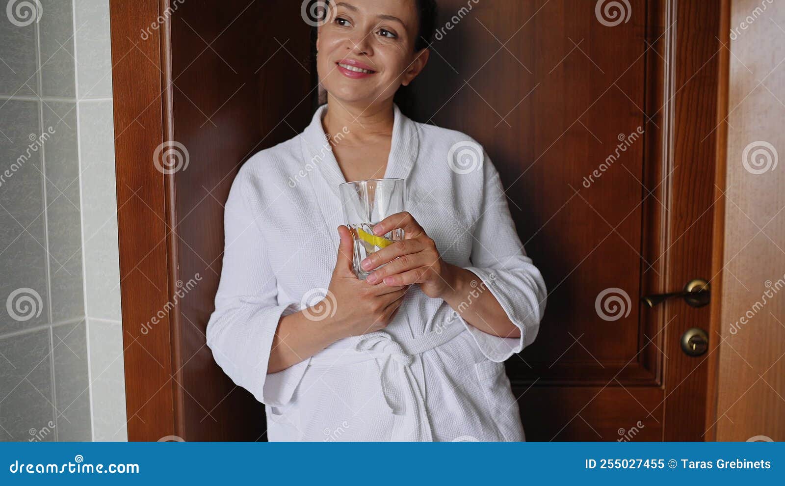 Beautiful Woman In White Waffle Bathrobe With Glass Of Fresh Lemon