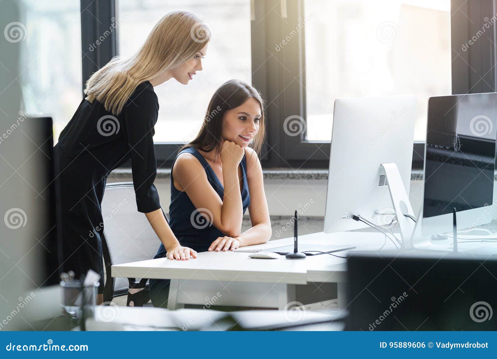 Beautiful Women Working Together in the Office on a Computer Stock ...