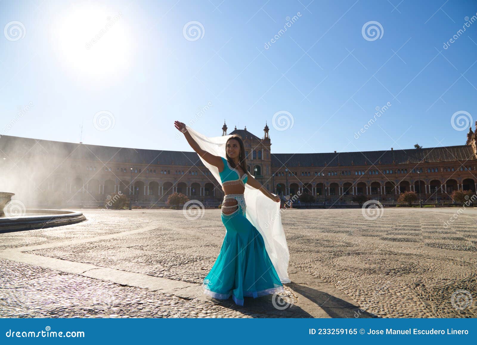A Beautiful Young Belly Dancer Dancing in a Square with a Backlight and ...
