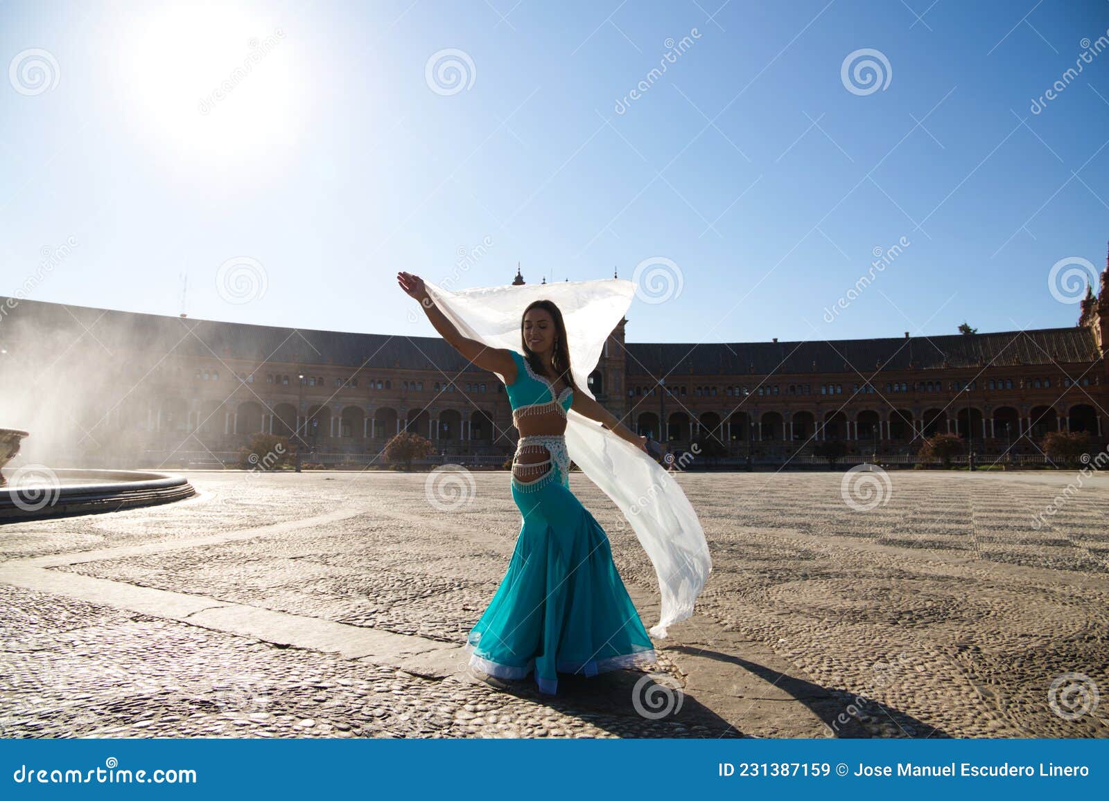 A Beautiful Young Belly Dancer Dancing in a Square with a Backlight and ...