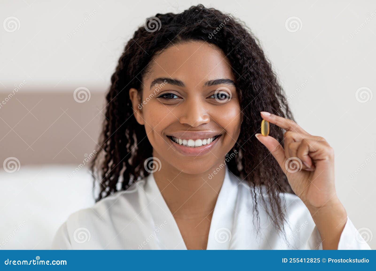 Beautiful Young Black Woman Holding Vitamin Pill Capsule and Smiling at ... Beautiful Young Black Woman Holding Vitamin Pill Capsule and Smiling at ...