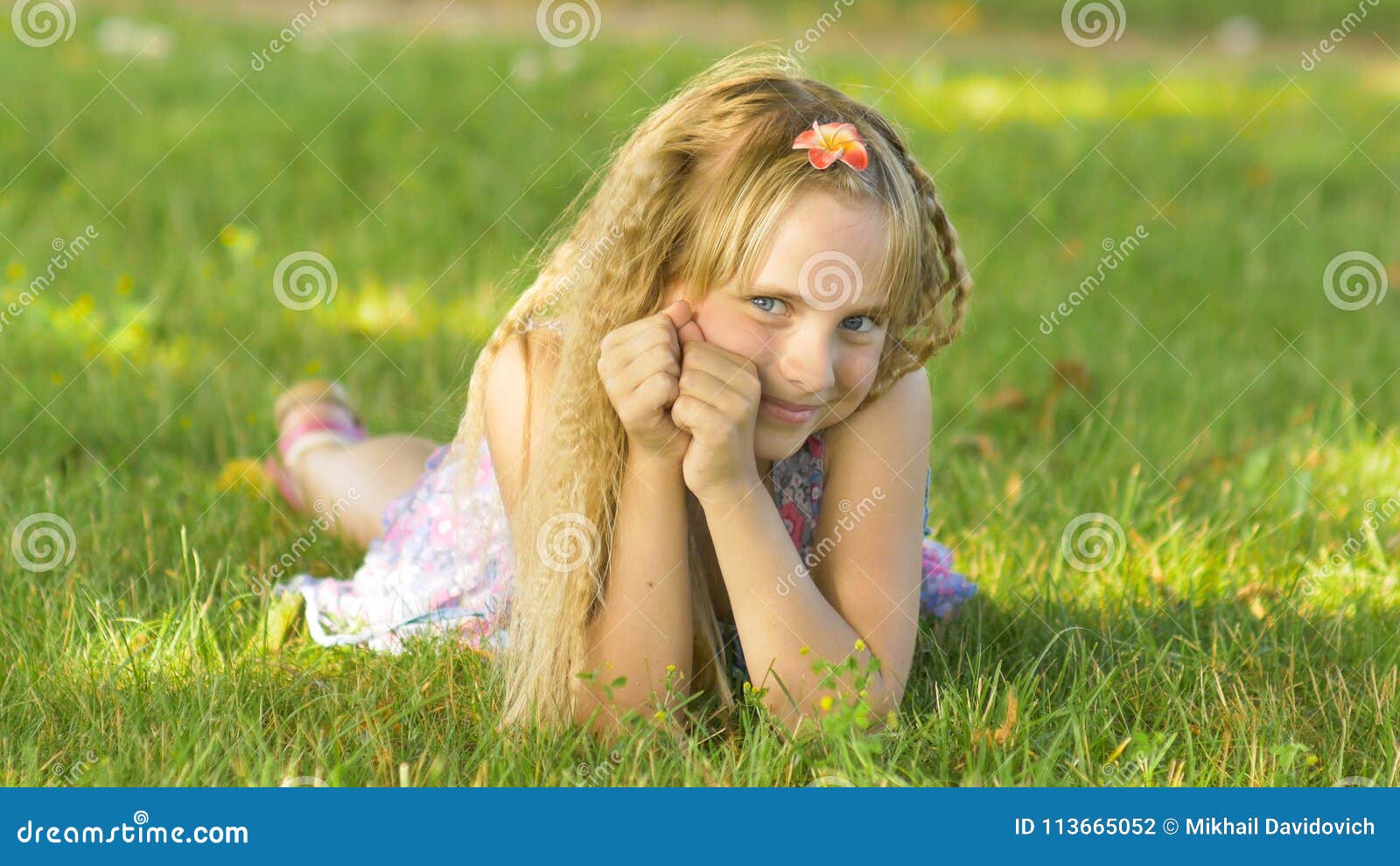 Beautiful Young Blonde Girl Lying On A Field Green Grass Outdoors