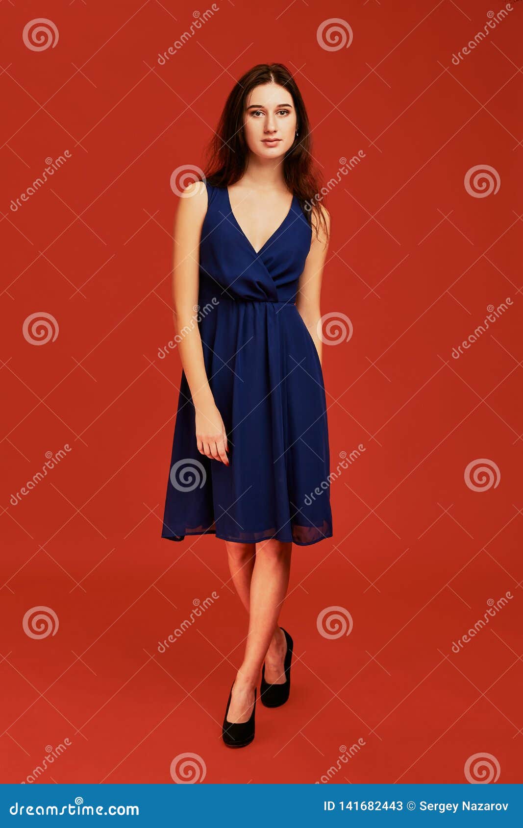 Beautiful Young Brunette Woman In Elegant Blue Cocktail Dress And Black