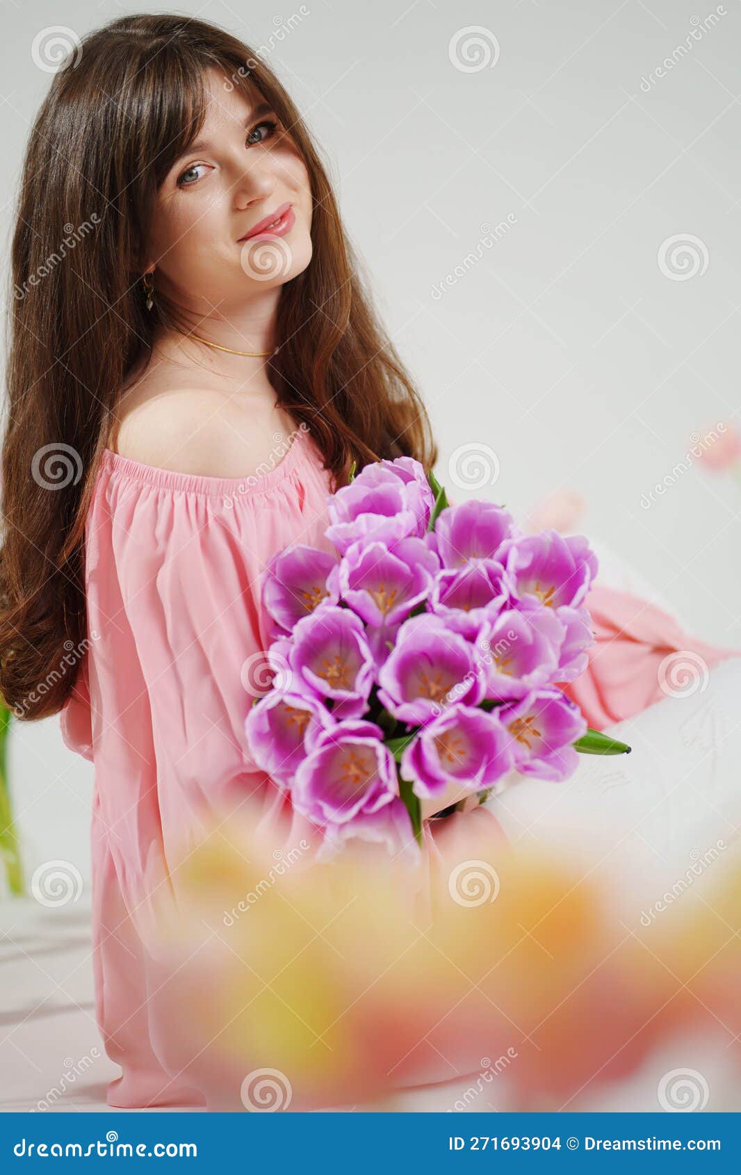 Beautiful Young Brunette Woman With Long Hair In Pink With A Bouquet Of